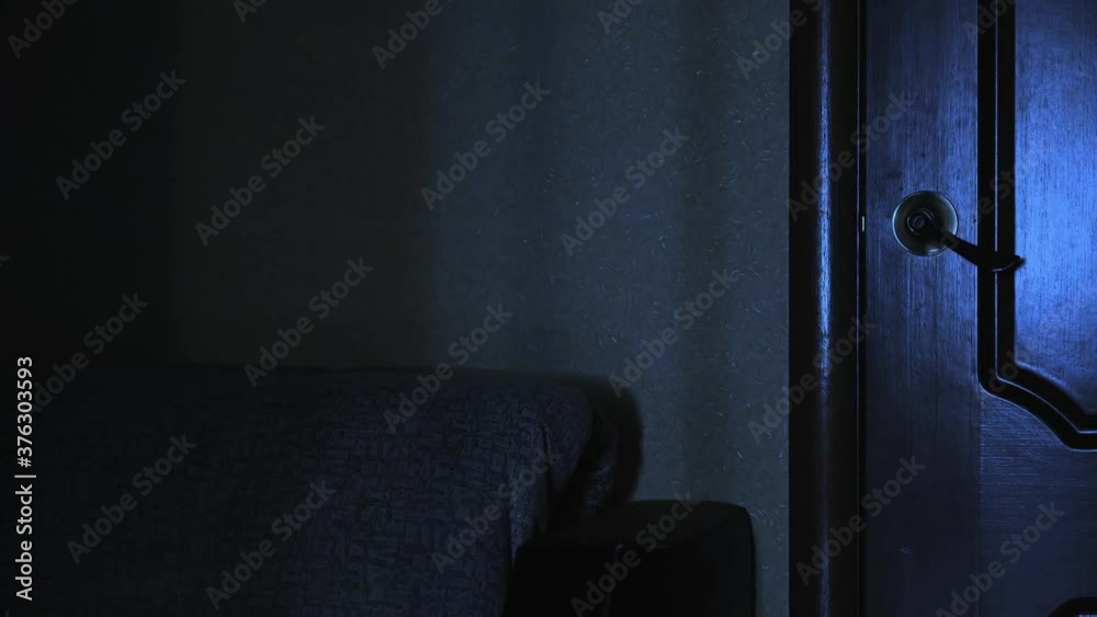 Halloween concept. A door opens behind the sofa and a monster's hand ...