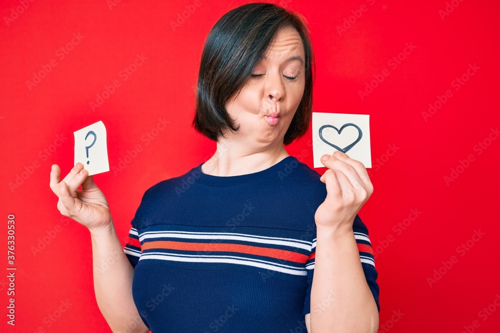 Brunette woman with down syndrome holding heart and question mark ...