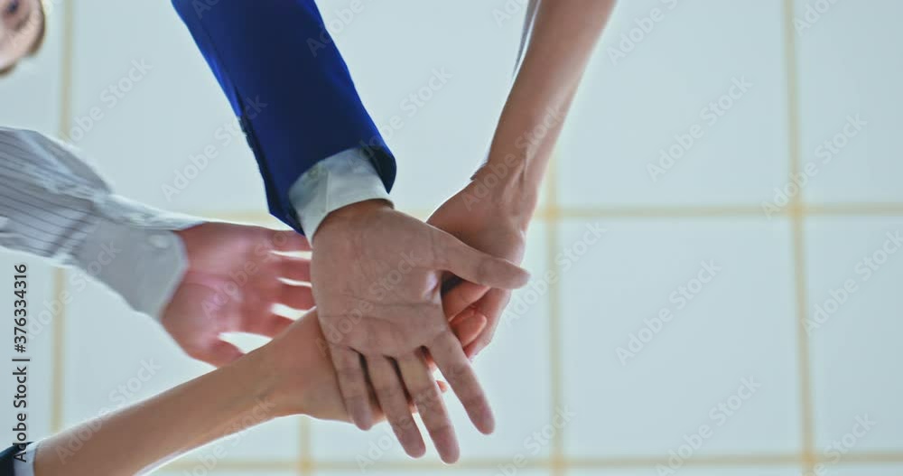 Close-up, a team of people of different nationalities puts hand on hand ...