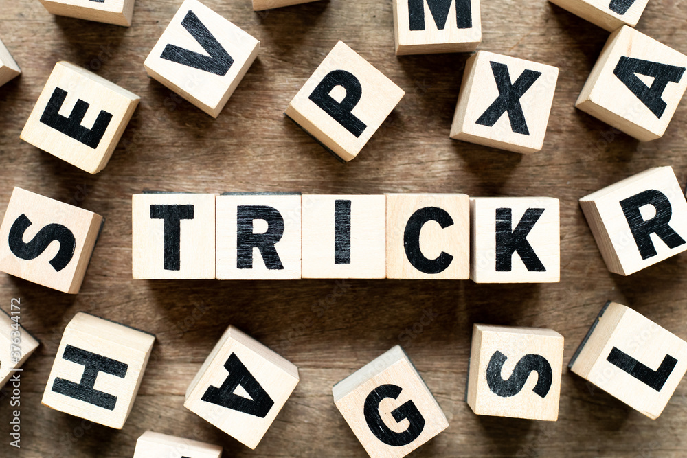 Letter block with word trick on wood background with another alphabet ...