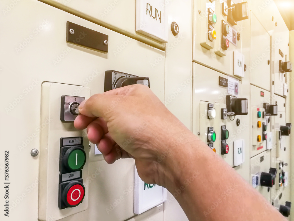 Hand holding the control panel of the industrial plant and pushing or ...