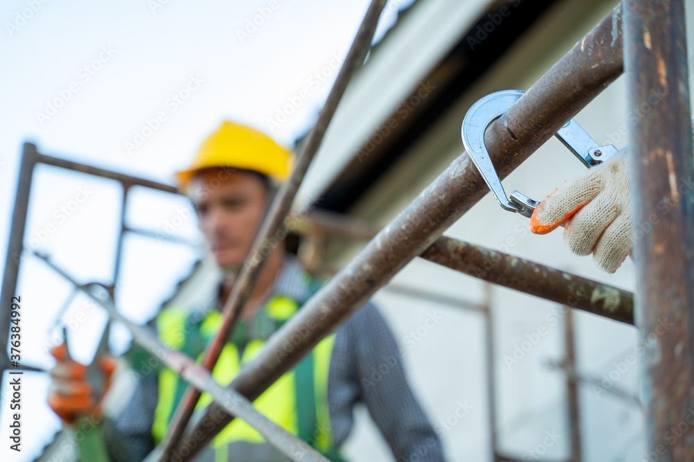 Professional worker wearing safety harness and safety line working on ...