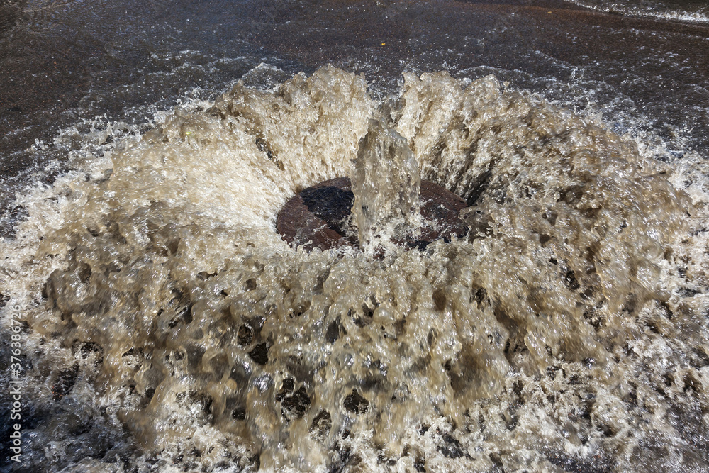 Water flows out of drainage hatch. Drainage fountain of sewage ...