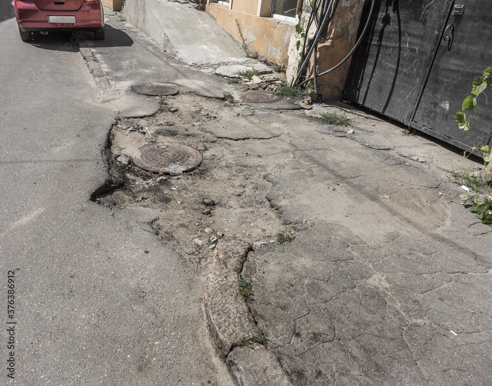 Damaged bad asphalt road, cracked asphalt with potholes and stains ...