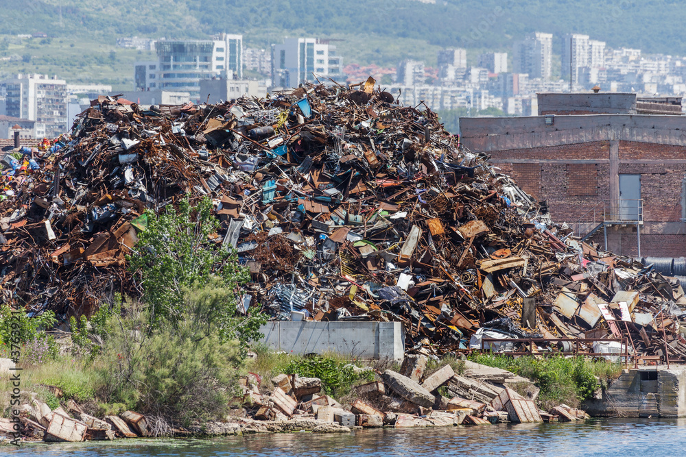 A large heap of scrap metal in the processing and loading area in sea ...