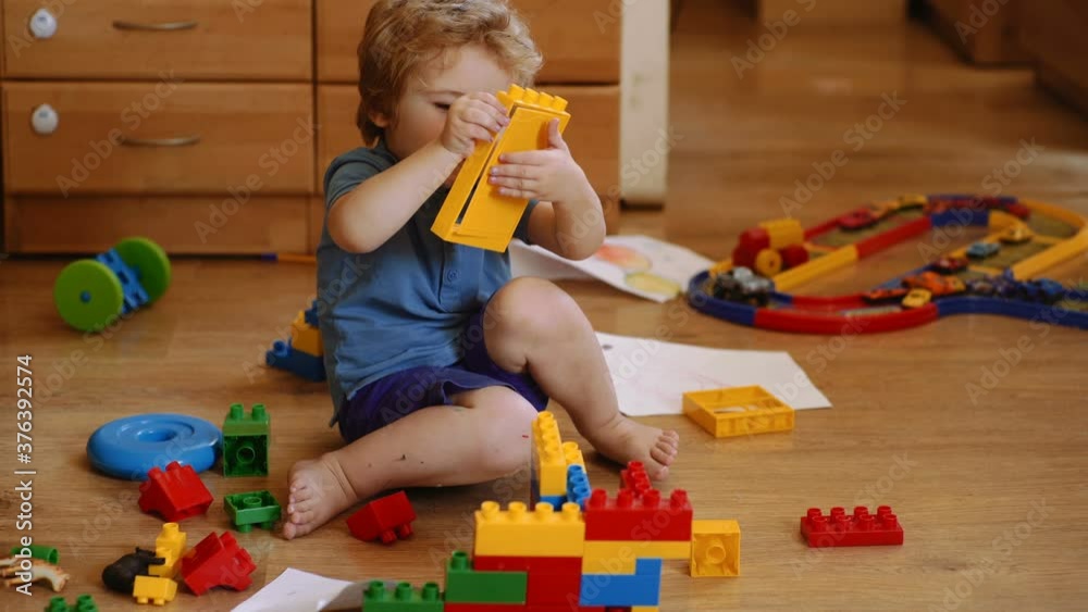 Child playing and building with colorful plastic bricks. Early learning ...