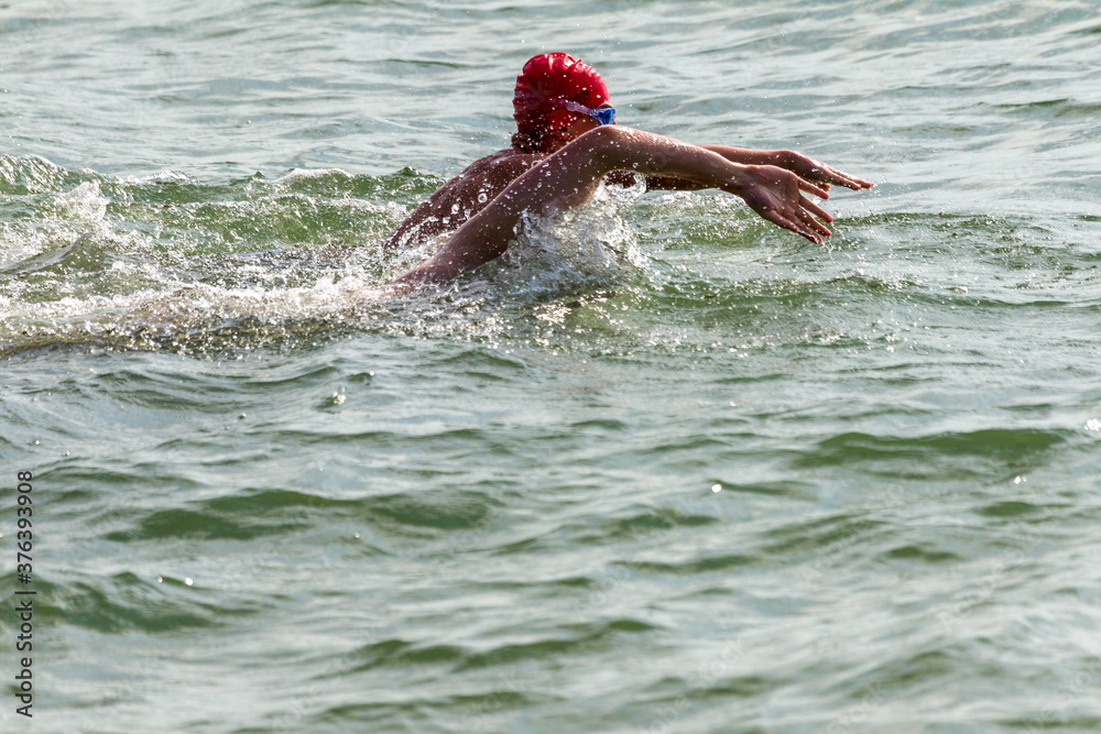 Swimmer swims in sea. Athlete triathlete swimmer drains from water. A ...