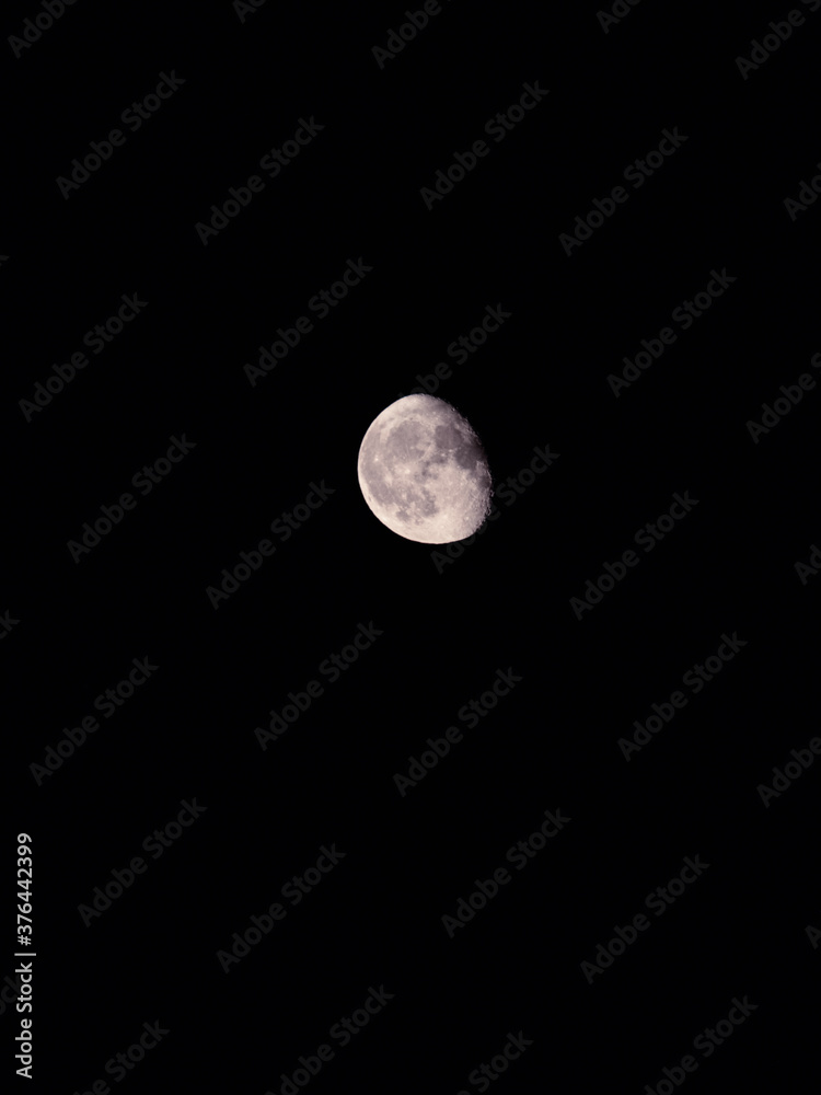 Bright white moon in waning gibbous phase on dark clear night sky ...