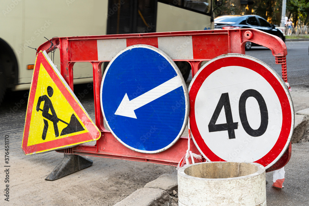Repair of asphalt road surface. Road signs standing on the road being ...