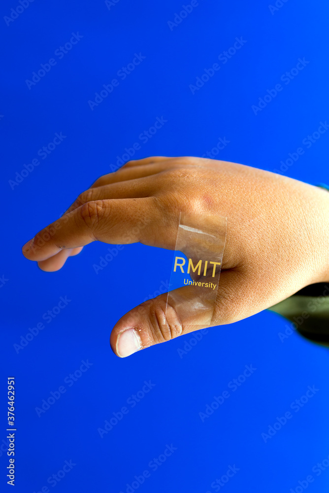Boy human hand an adhesive transparent tape is glued to it.Blue studio ...