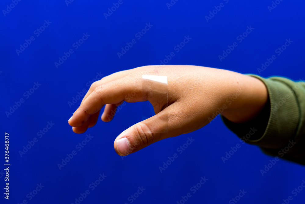 Boy human hand an adhesive transparent tape is glued to it.Blue ...