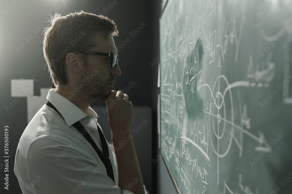 Young smart mathematician drawing on the chalkboard Stock Photo | Adobe ...