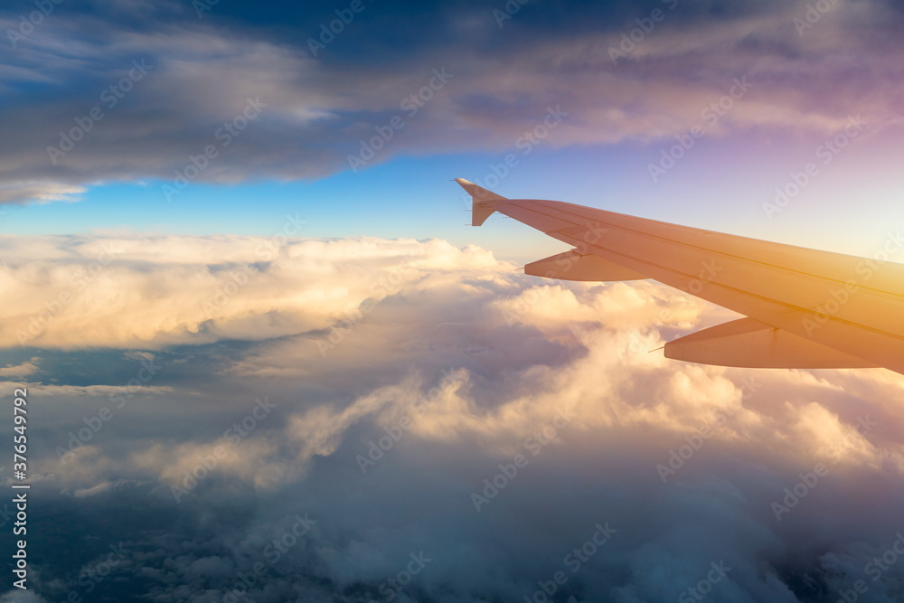 Flying and traveling, view from airplane window on the wing on sunset ...