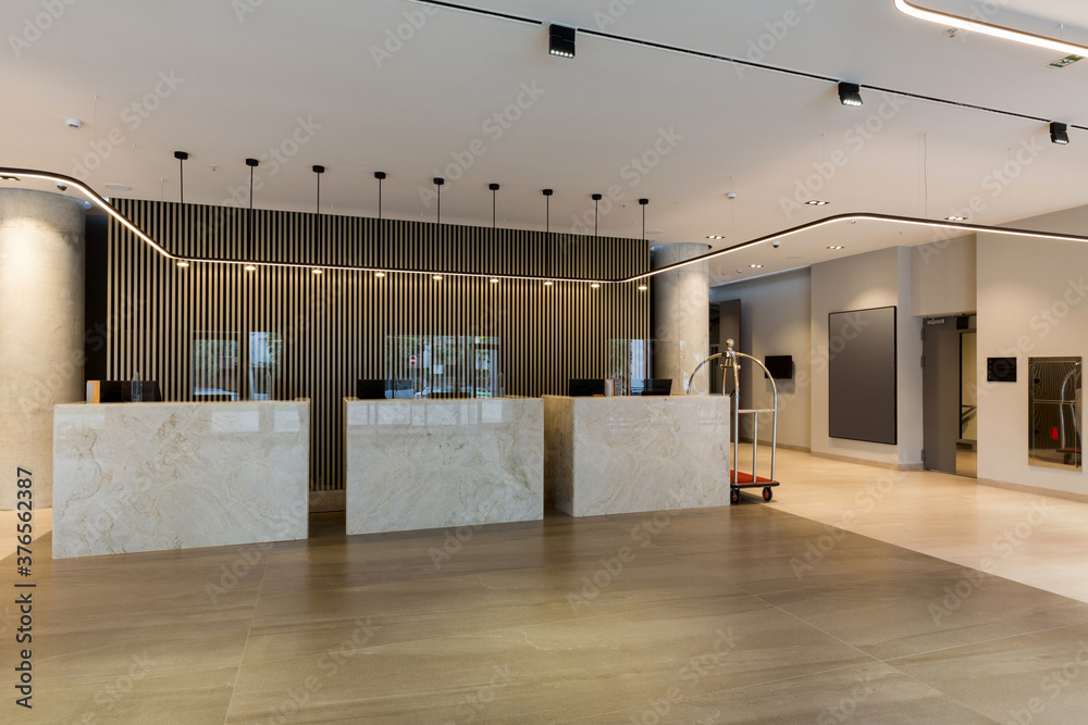 Interior of a hotel lobby with reception desks with transparent covid ...