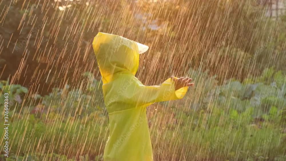 Little happy cute smiling boy child raised hands in yellow raincoat and ...