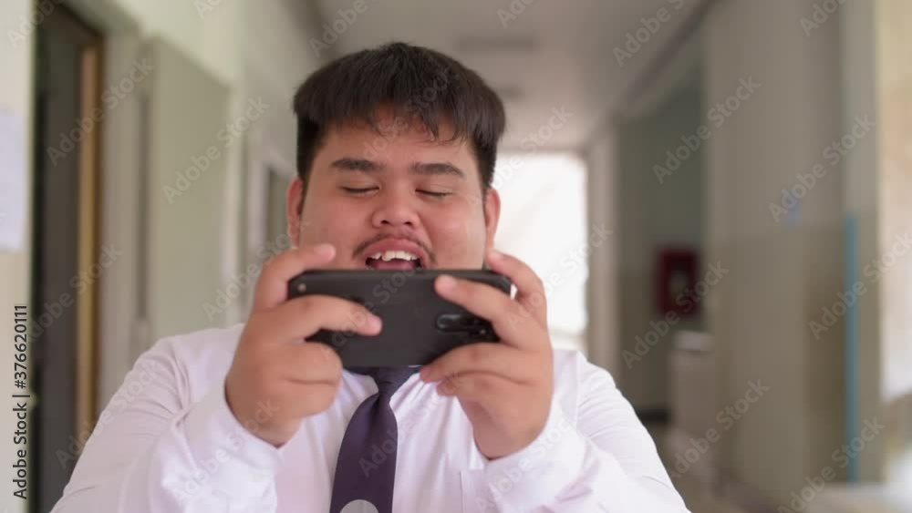 A funny fat Asian man wearing an office suit and wearing a necktie and ...