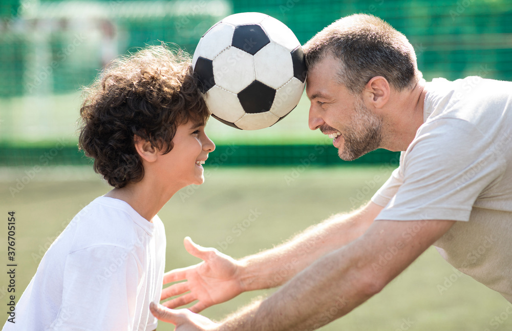 Foto de Man holding ball between two heads with little boy do Stock ...