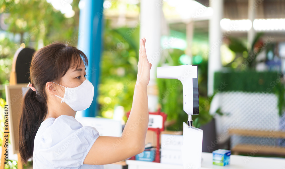 Disease control experts use an Infrared thermometer equipment to check ...