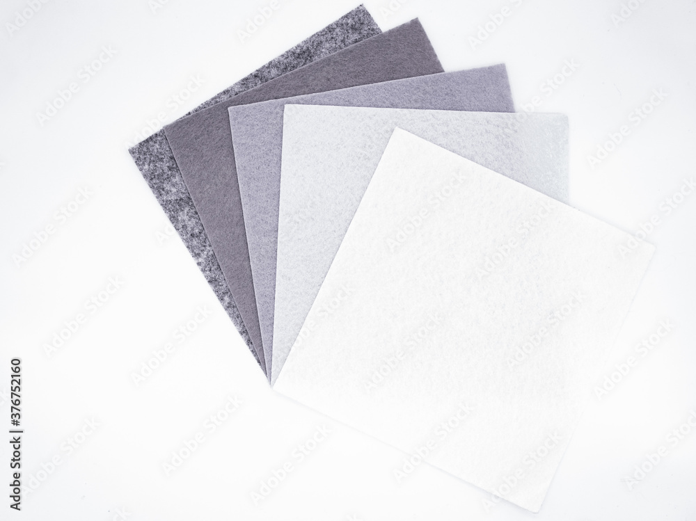 Five square pieces of felt of different shades of gray from dark to ...