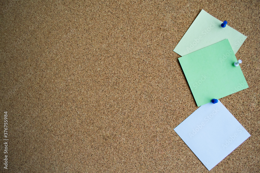 Three paper notes green, white and yellow color on a cork Board ...