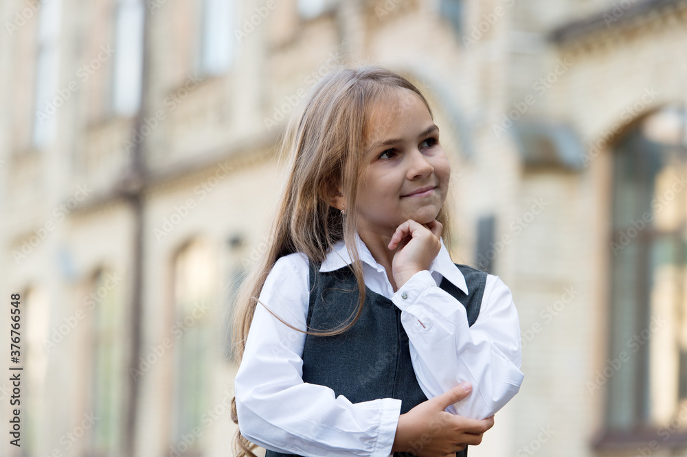 Happy little child lost in thoughts with thoughtful look in school ...