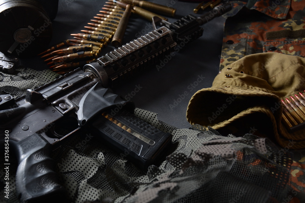 Assault rifle (M4A1) with ammunition on camouflage uniform,and military ...