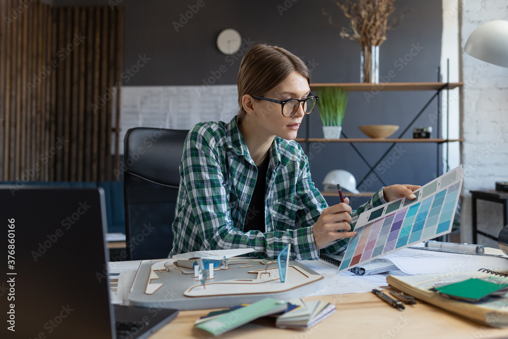 Female interior designer working in office with color palette ...
