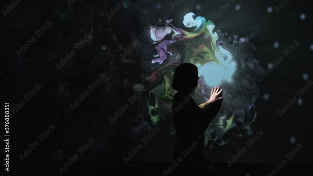 Silhouette of girl draws multi-colored paints interactive installation ...