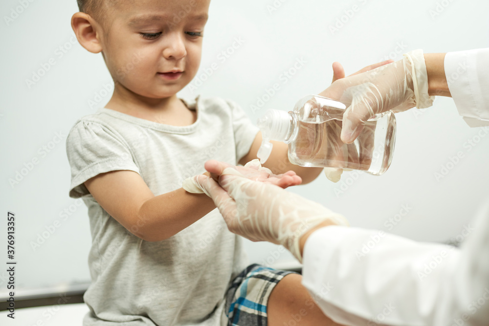 Doctor putting hand sanitizer to baby hands. Teaching a baby boy hand ...
