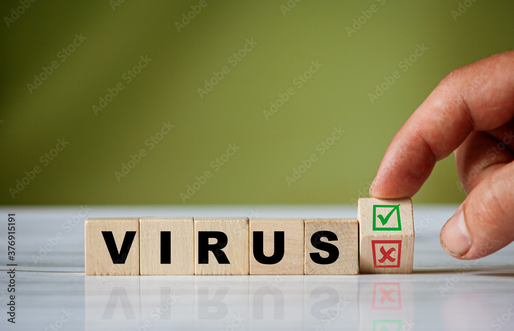 The hand turns the wooden cube and changes the word VIRUS with green ...