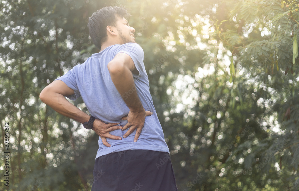 Young Asian runner sustains a back pain injury, Sport injury, Man with ...