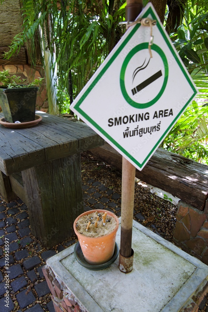Designated smoking area sign on a board in front of the restaurant ...