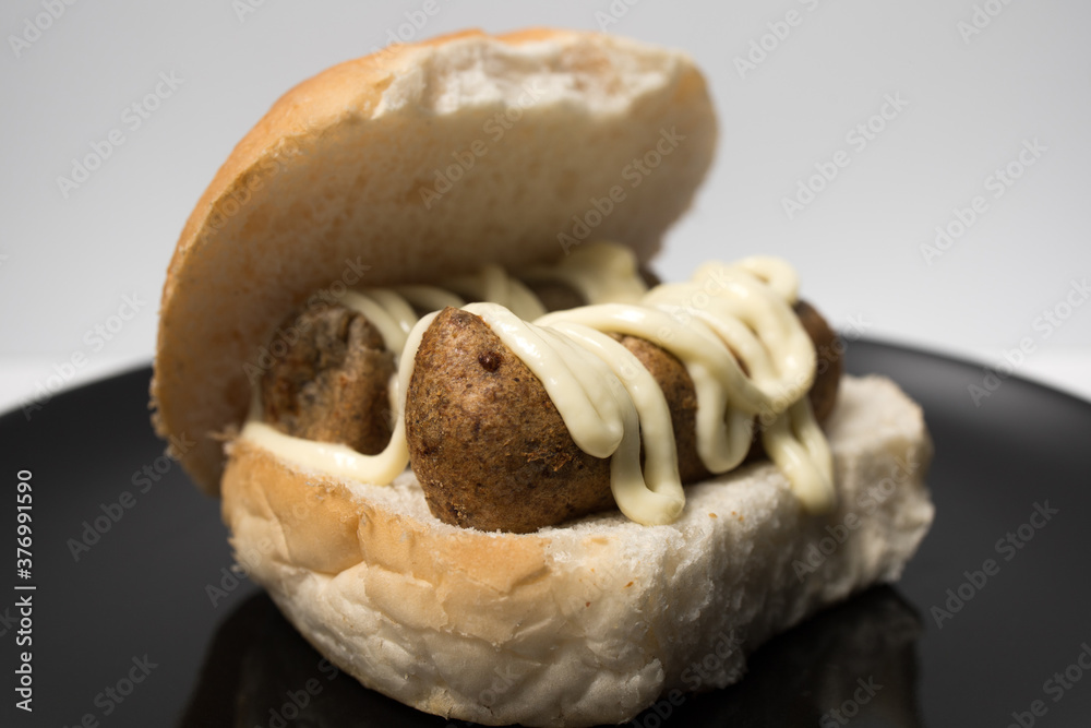 Closeup of dutch snack broodje frikandel met mayonaise sauce. Deep ...