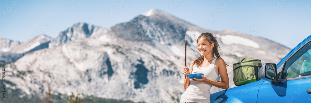 Travel driver woman eating food on camping road trip by her car ...