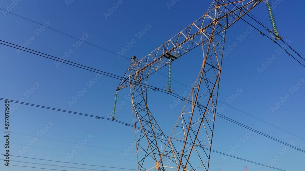 Stockvideo Transmission tower supporting an overhead high voltage power ...