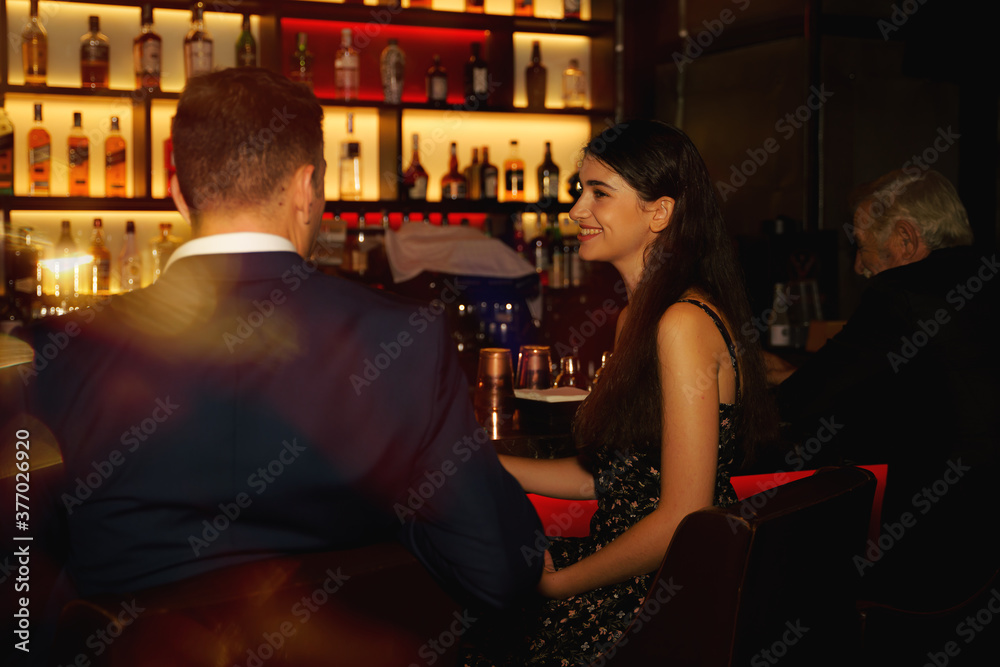 businesspeople having relaxed discussion at counterbar in nightclub ...