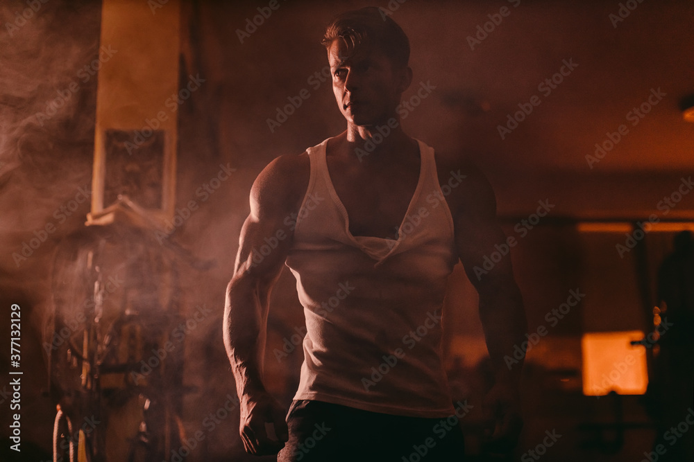 Powerful Muscular man posing in darkness. Dark portrait of handsome ...