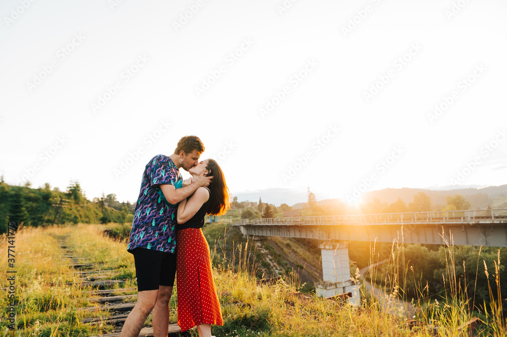 Beautiful couple of young people kissing standing on a viaduct on a ...