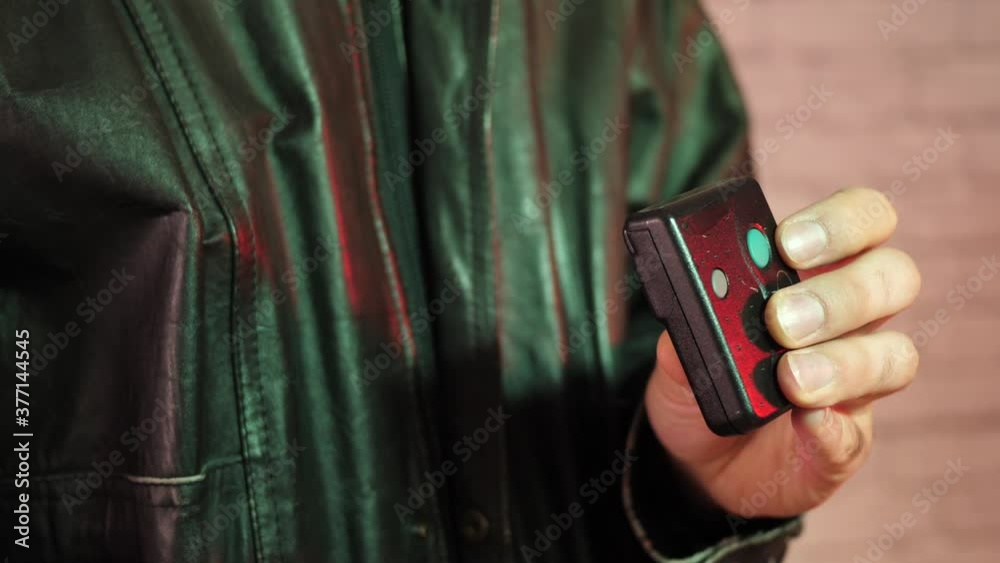Man wearing a leather jacket using a vintage pager beeper. vídeo de ...