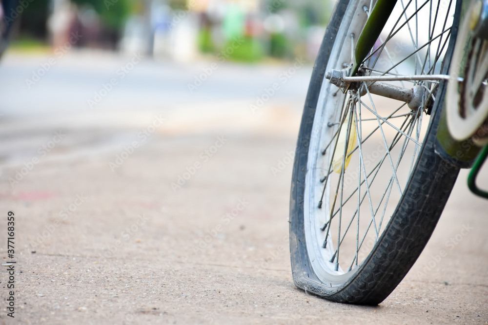 The rear wheel of the bicycle is flat and is left parked on the ...