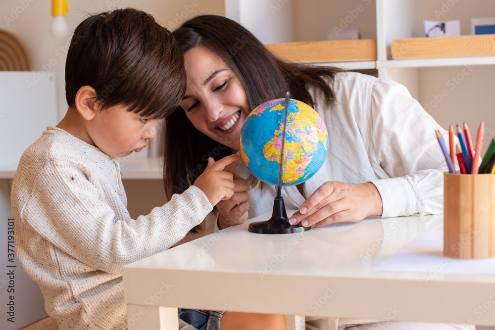 Preschooler Kid learing geography with a globe map and teacher educador ...
