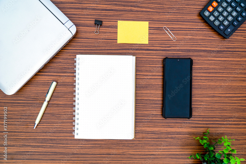 An office table working enviroment. Notepad, sticky note, pen plant ...