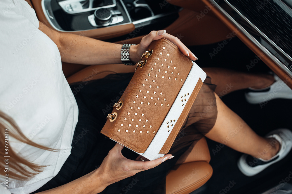 Women is holding handbag at the luxury car. Lady with bag inside modern ...
