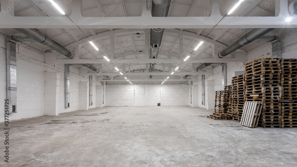 Industrial building interior with white brick walls, concrete floor and ...