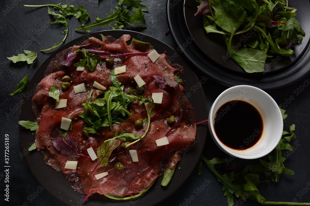Beef Carpaccio with parmesan, capers and arugula. With olive oil and ...