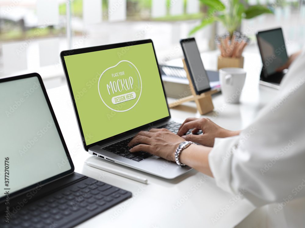 Female office worker working on her project with mock up laptop ...
