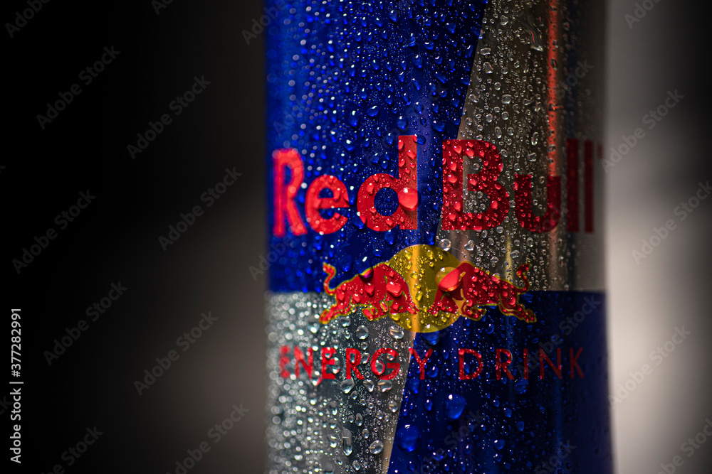 Aluminum can of RedBull drink with water drops over dark background ...