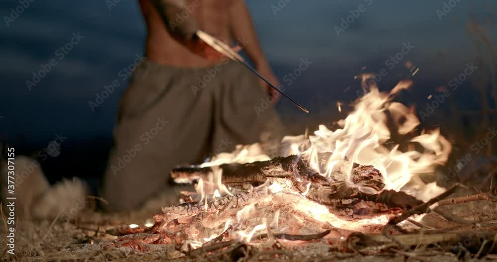 Vidéo Stock Barbarian warrior heating sword in fire. Tilt up view of ...