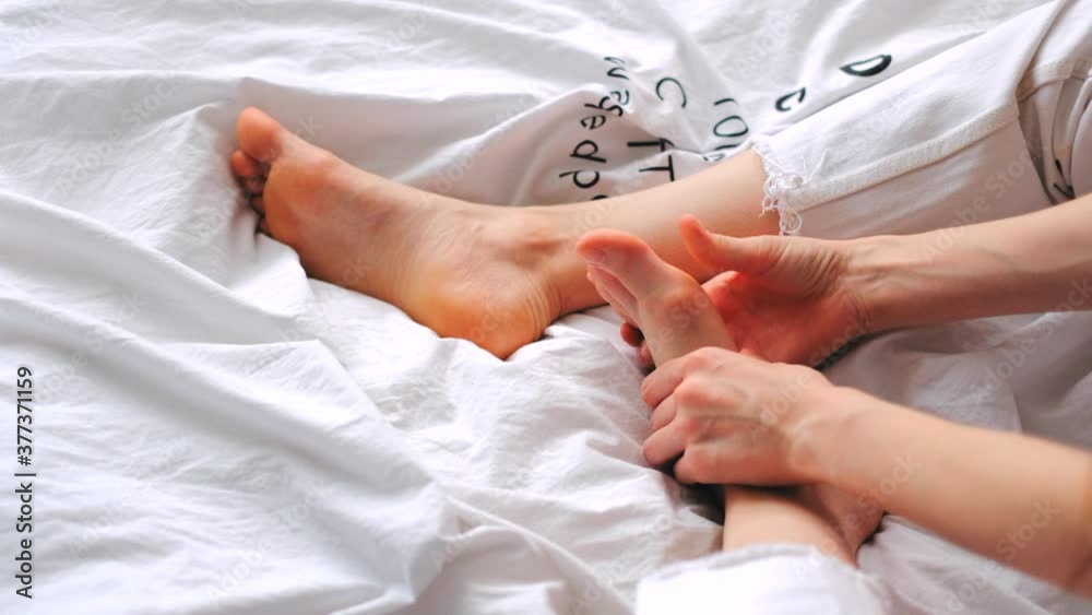 Woman Sitting On The Bed Massages Her Foot Close Up Woman With A