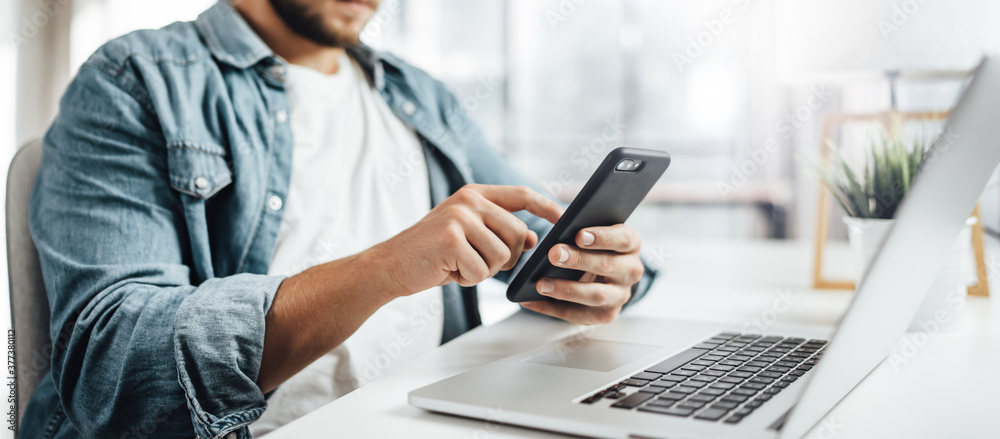 Young man with smartphone in his hands. Modern businessman at sunny ...